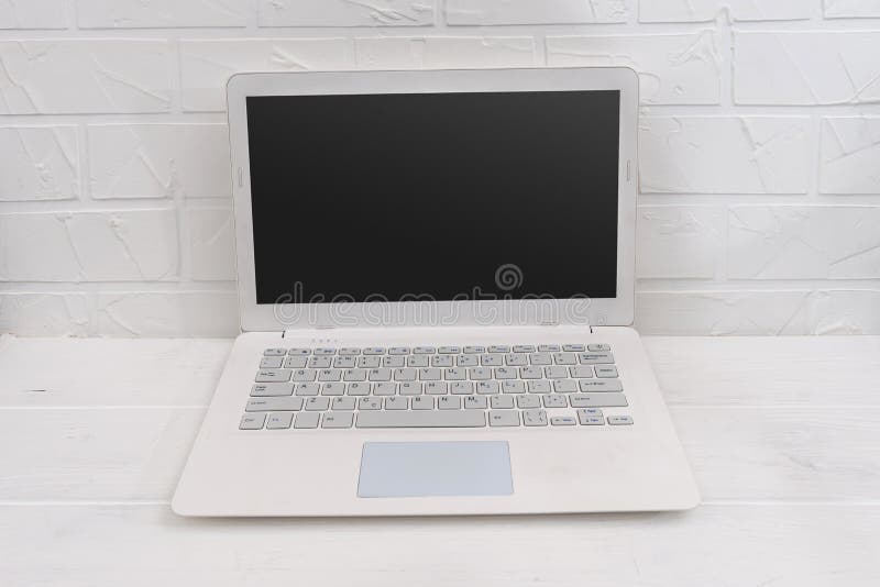 White Laptop on the Table and White Wall Behind Stock Image - Image of ...