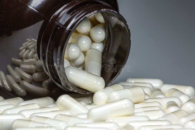 White Large Pills Falling Out of a Large Pill Bottle Stock Image ...