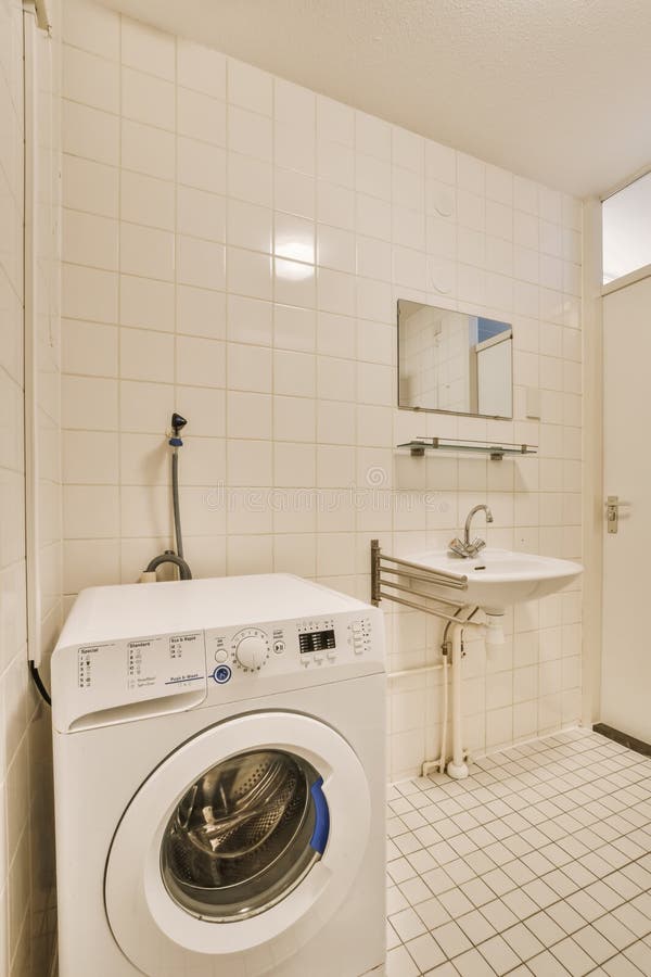 A White Laundry Room with a Washing Machine in it Stock Photo - Image ...
