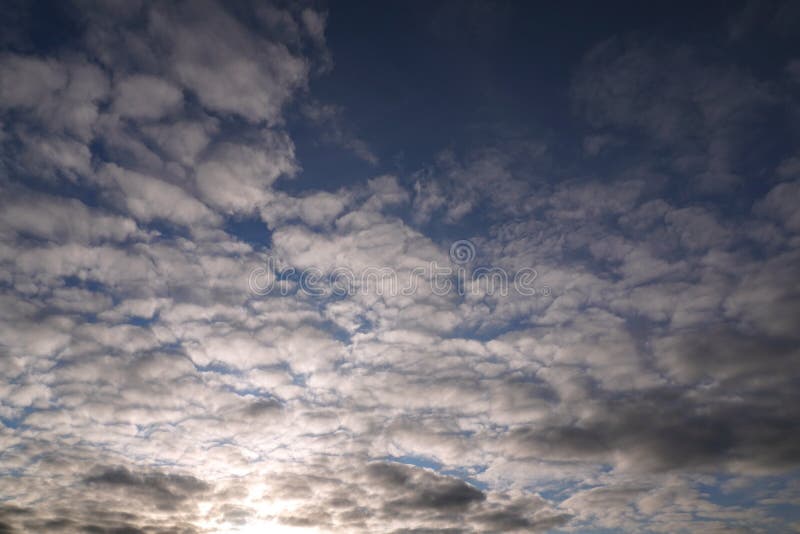 White Light Fluffy Clouds in a Blue Sky with a Solar Flare Stock Image ...