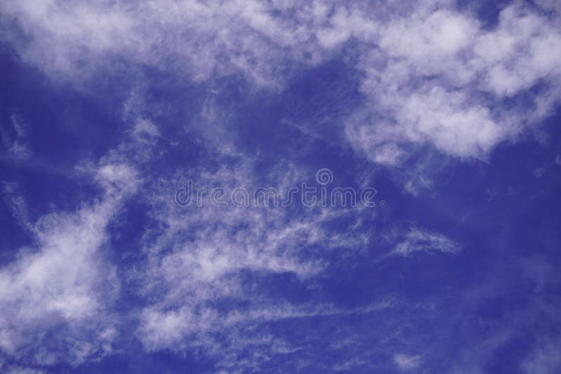White Light Fluffy Clouds in a Blue Sky with a Solar Flare Stock Image ...