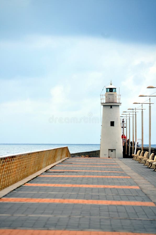 White Lighthouse at the Bottom of the Road Stock Image - Image of inlet ...