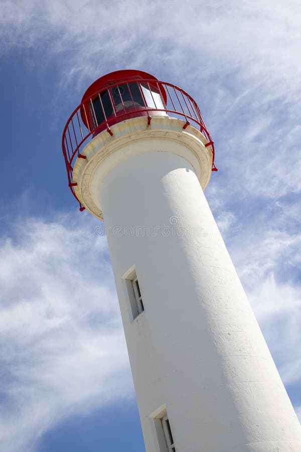 White Lighthouse with Windows and Its Red Top from a Low Angle with a ...