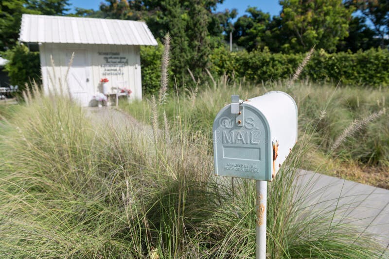 White Mailbox on Pole at Grass Meadow in Front of Cabin Stock Image ...