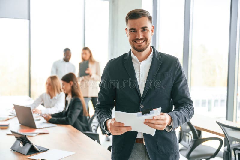 White Man in Suit is with Papers in Hands, Standing. Group of Office ...