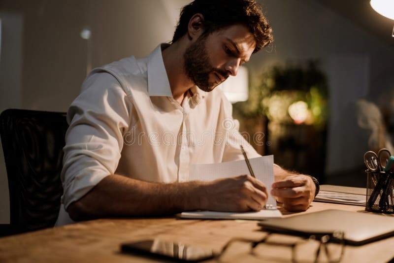 White Man Writing Down Notes in Planner while Working at Office Stock ...