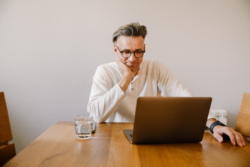White Mid Man Smiling and Using Laptop while Sitting at Table Stock ...