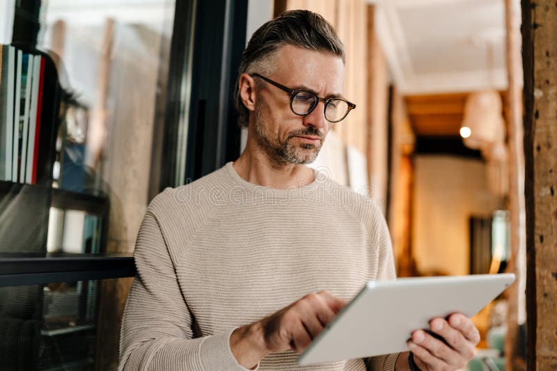 White Middle-aged Man Using Tablet Computer while Working in Office ...