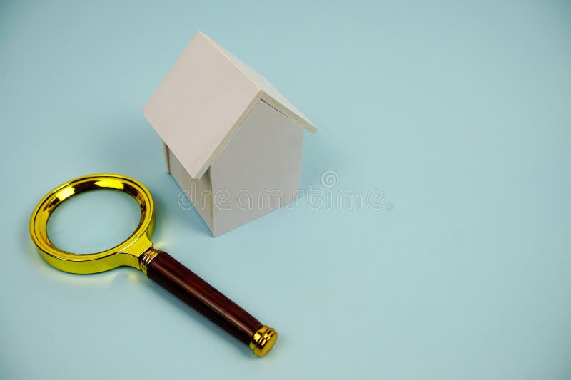 White Model House and Magnifying Glass with Space Copy on Blue ...
