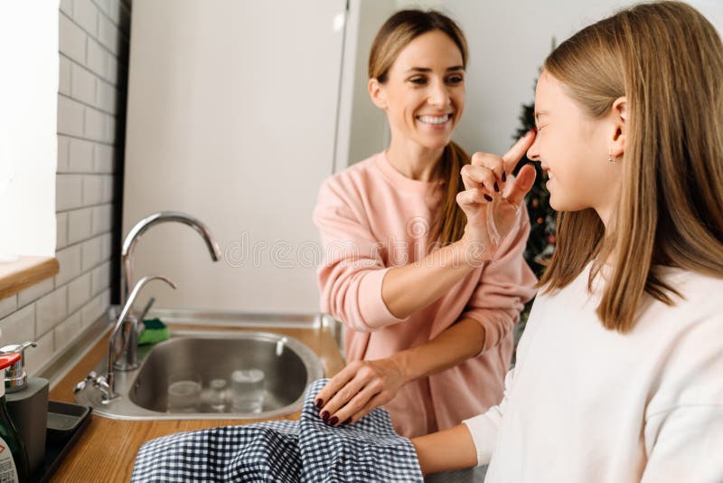 White Mother and Daughter Making Fun while Washing Dishes in Kitchen ...