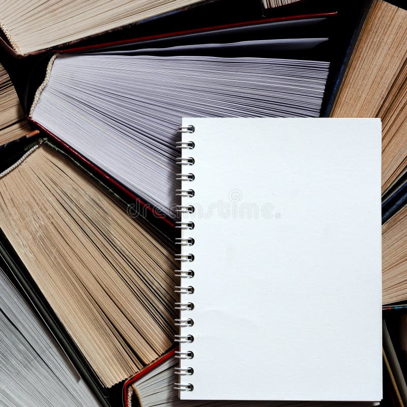 A White Notebook With Clean Pages Rests On Old Multicolored Books Stock ...