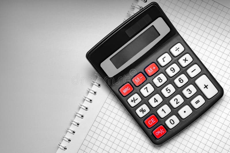 White Notebook and Digital Calculator with Red Buttons on a White Table ...