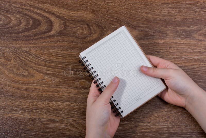 Notebook in Hand on a Brown Color Background Stock Image - Image of ...