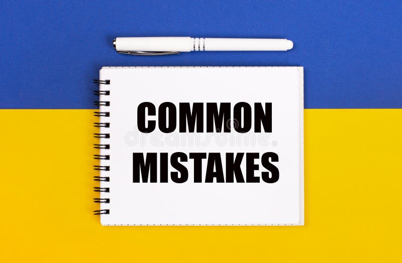 A White Notebook with the Text COMMON MISTAKES and a White Pen on a ...