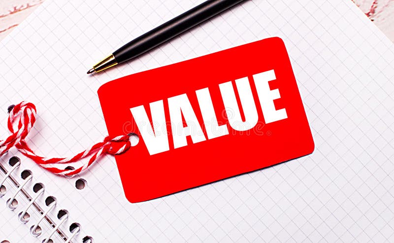 On a White Notebook There is a Black Pen and a Red Price Tag on a ...