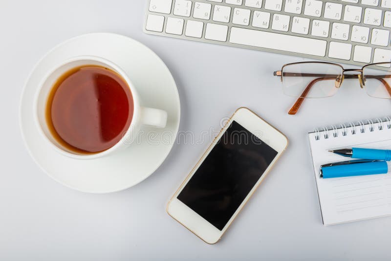 White Office Desk Table with Computer Keyboard, Smartphone, Cup of Tea ...