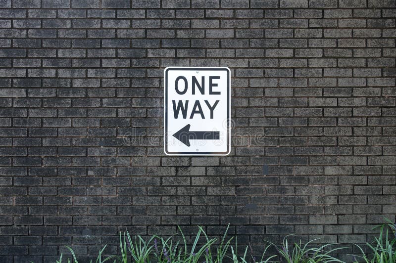 One Way Sign Posted on a Brick Wall Stock Image - Image of wall ...
