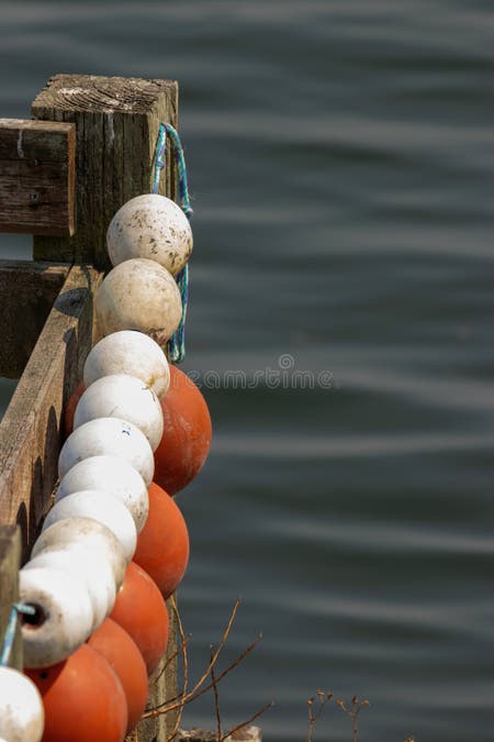 White and Orange Floats on Strings Over Water Stock Image - Image of ...