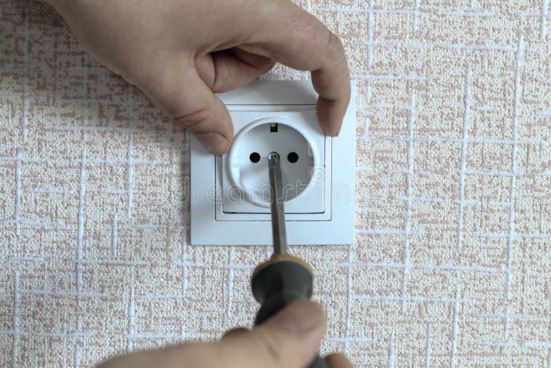 . White Outlet. the Wizard with a Screwdriver Sets it in Place Stock ...