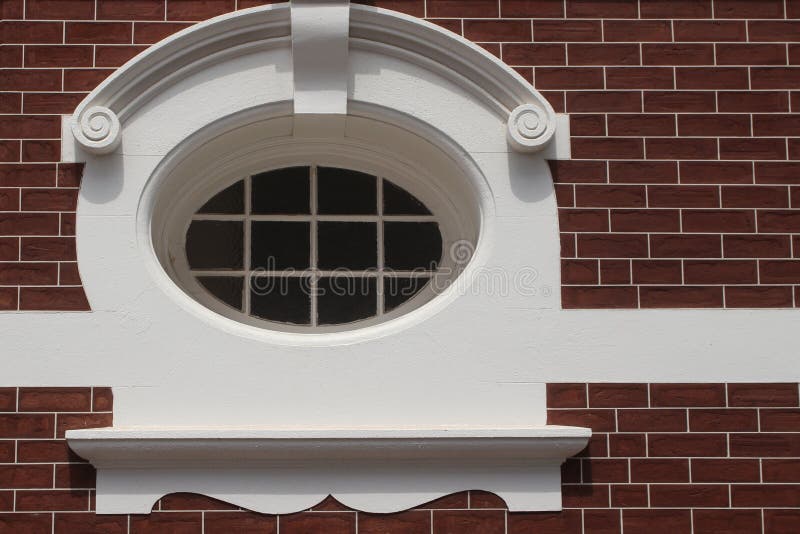 White Oval Window with Stucco in Ruby-colored Brick Wall Stock Image ...