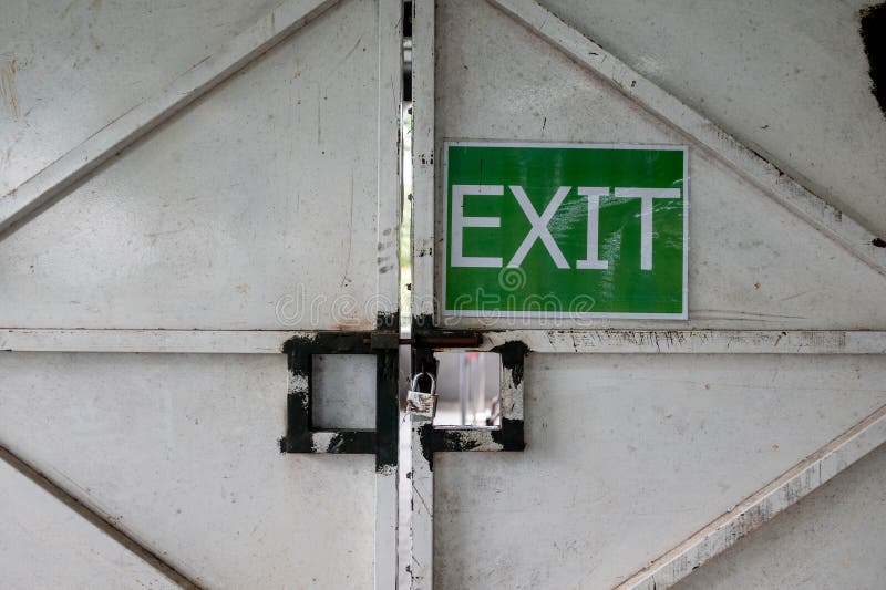 A White Painted Metal Gate with EXIT Sign in a Building Construction ...
