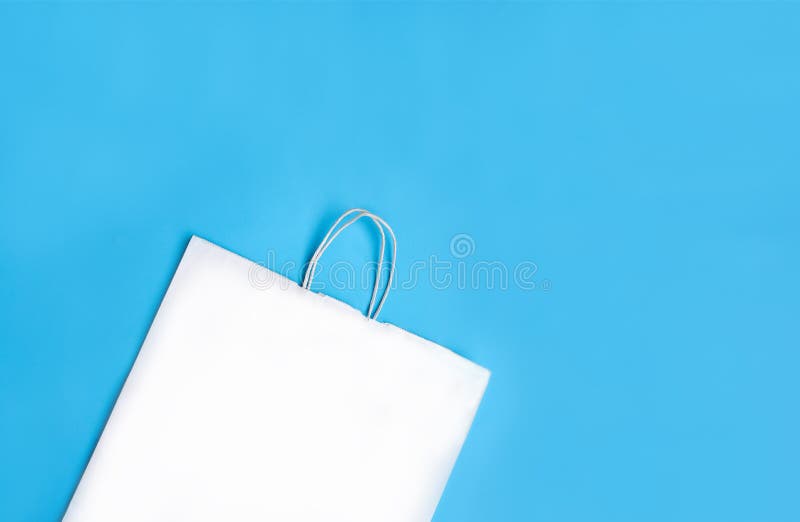 White Paper Package in Lower Left Corner on a Blue Background. Space ...