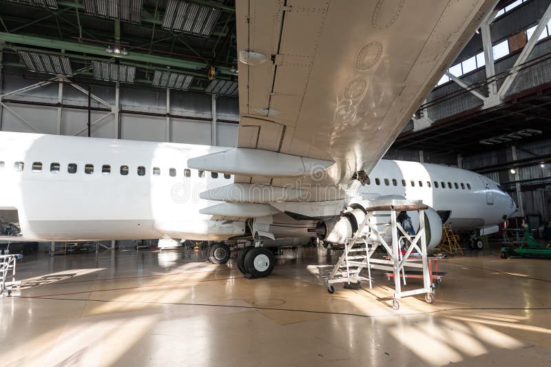White Passenger Airplane in the Aircraft Hangar. Checking Mechanical ...