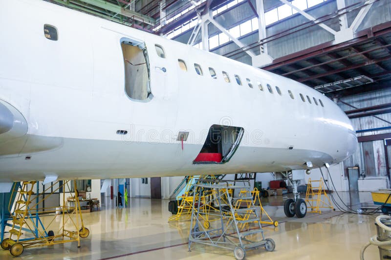 White Passenger Airplane in the Hangar. Aircraft Under Maintenance ...