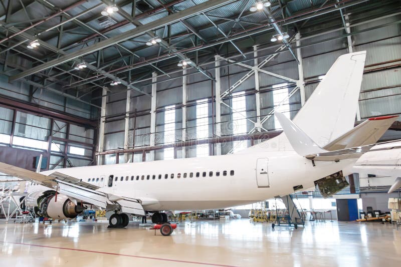 White Passenger Plane in the Airplane Hangar. Aircraft Under ...