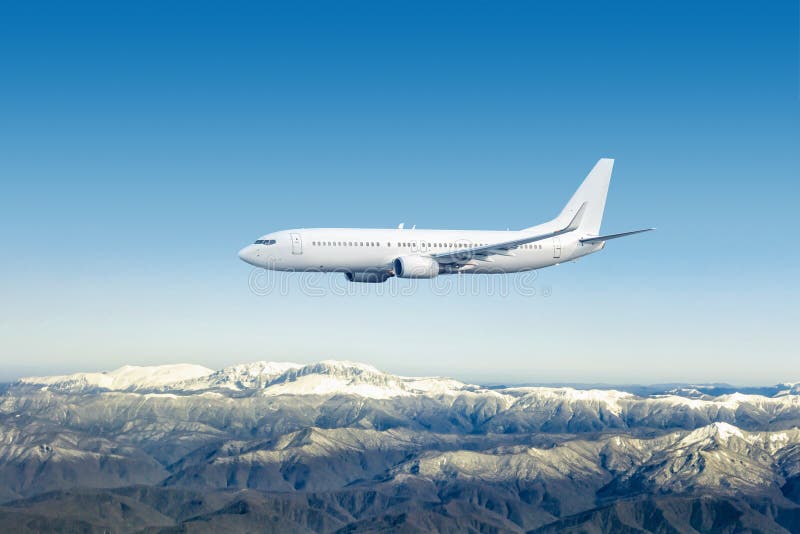 White Passenger Plane Flies Over Snow Covered Mountains Stock Photo ...