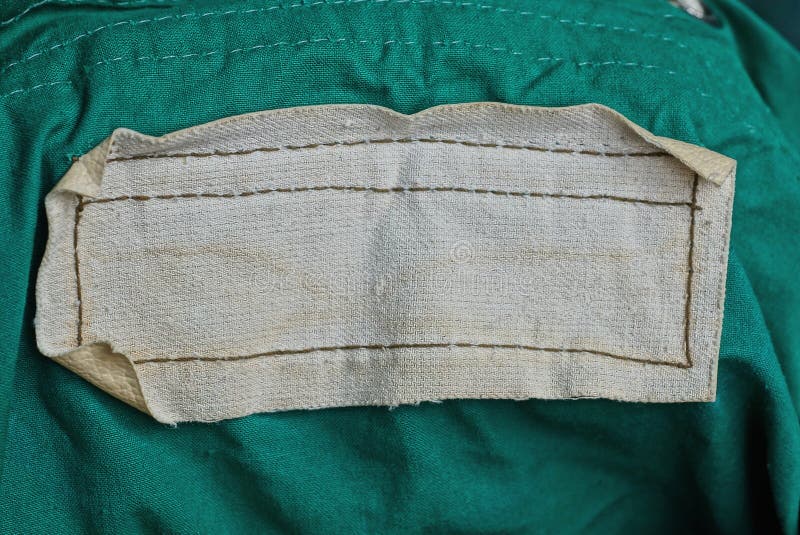 White Patch Made of Fabric on Green Cloth Stock Photo - Image of ...