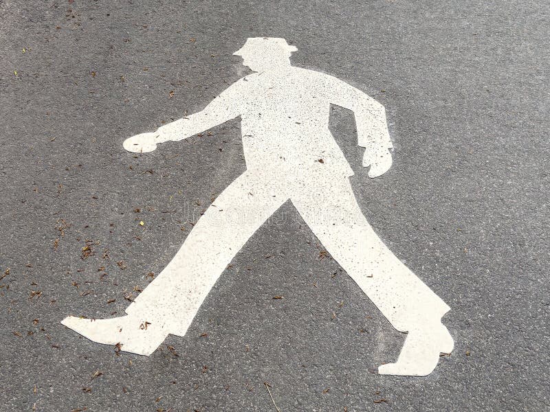 White Pedestrian Silhouette on Asphalt Road Surface Symbolizing Walking ...