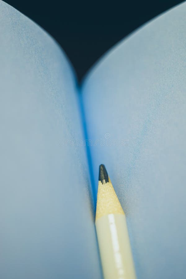 White Pencil in a Blue Notebook on Clean Paper Stock Photo - Image of ...