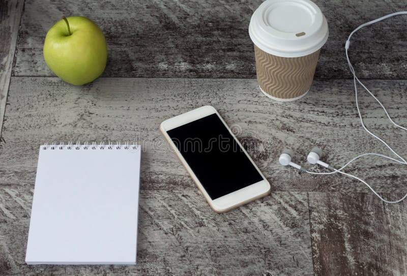 White Phone with Headphones, Coffee, Notepad and Green Apple on the ...