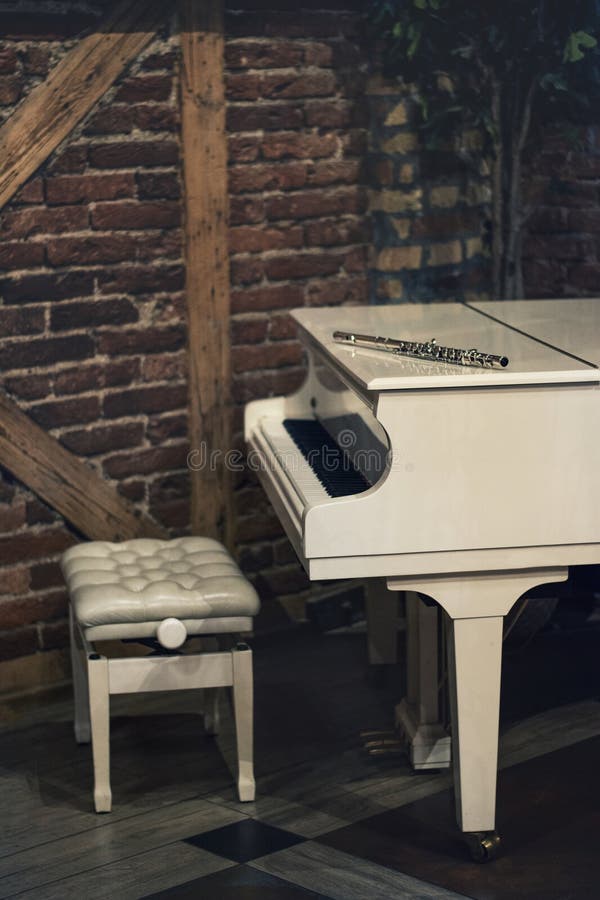 White Piano with a Flute on it in a Rustic Interior Stock Photo - Image ...
