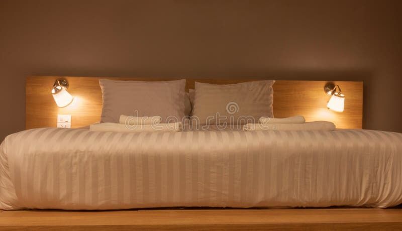 White Pillows and Blanket in Bed with Light from Lamps at Night Stock ...