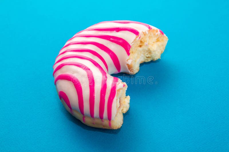 White Pink Half-bitten Donut Close-up on Bright Blue Background Stock ...