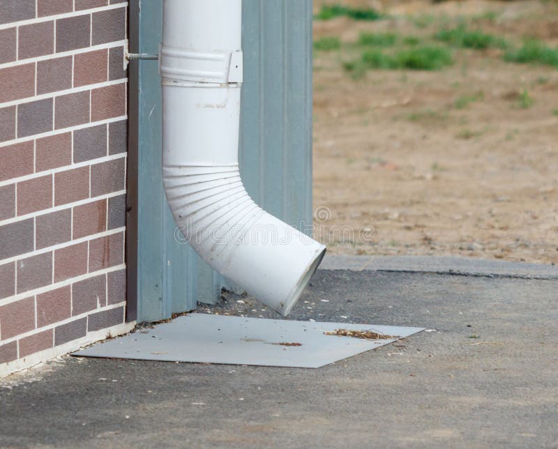 A White Pipe with a Hole in it is Leaning Against a Brick Wall Stock ...