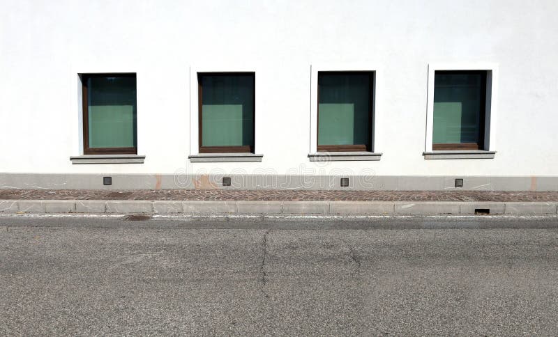 White Plaster Building with a Row of Windows at Roadside. Sidewalk and ...
