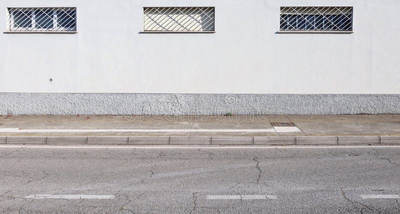 White Plaster Facade with Barred Windows at the Roadside. Cement ...