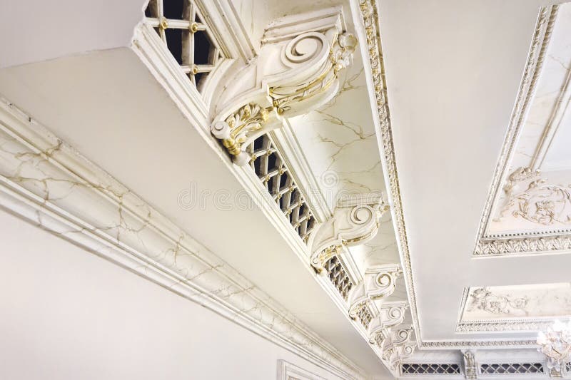 White Plaster Molding Elements with Gold Veins for Decorating the Ceiling in a Classic Style ...