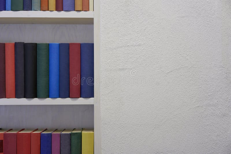 White Plastered Wall with Colorful Books in Bookshelf Stock Photo ...