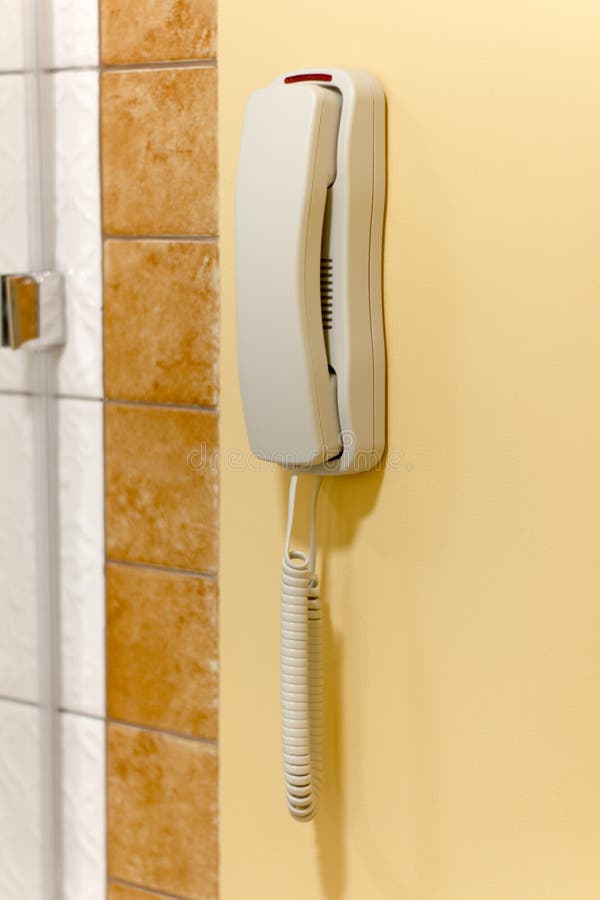 White Plastic Phone on a Wall for Emergency Call or Support. Stock ...