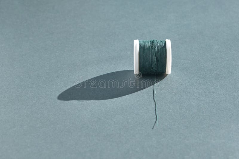 A White Plastic Spool of Sewing Thread in a Beautiful Emerald Color ...