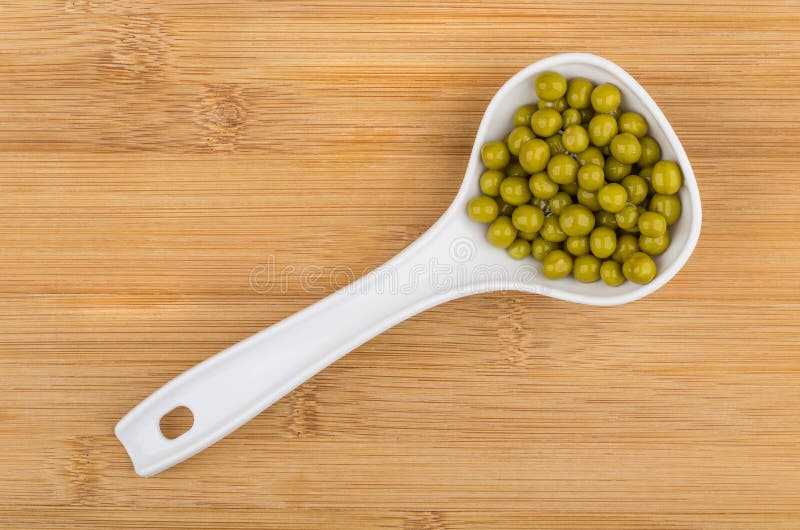 White Plastic Spoon with Green Peas on Wooden Table Stock Image - Image ...