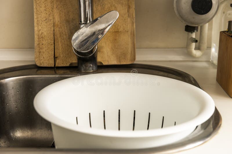 A White Plastic Strainer in a Kitchen Sink with a White Countertop ...
