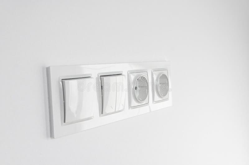 White Plastic Walk-through Switches and Sockets on a White Wall Stock ...