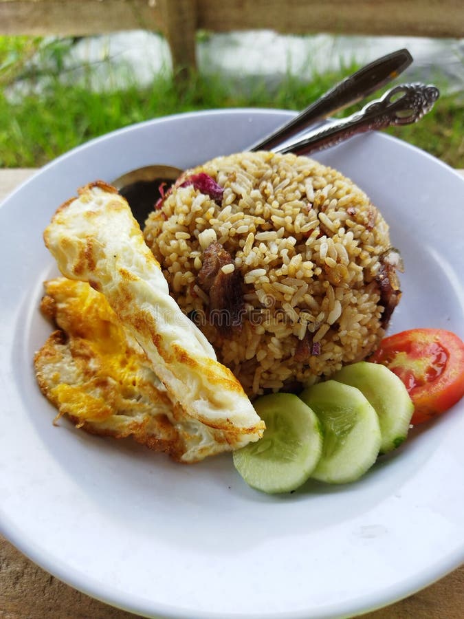 White Plate with Beef Fried Rice with Sunny Side Up Egg with Cucumber ...