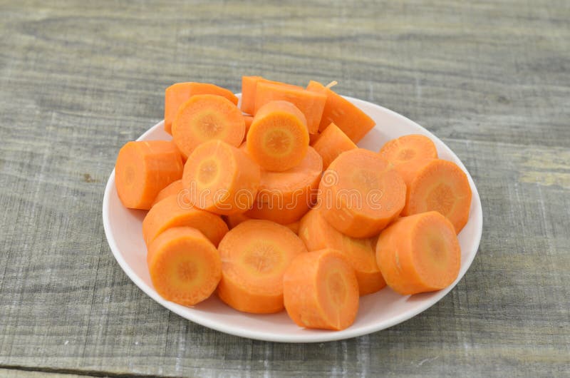 White Plate with Cut Carrots Thick on Wooden Background Stock Photo ...