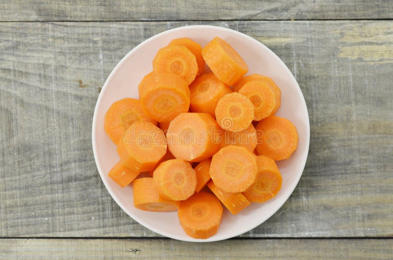 White Plate with Fresh Cut Thick Carrots on Wooden Background Stock ...